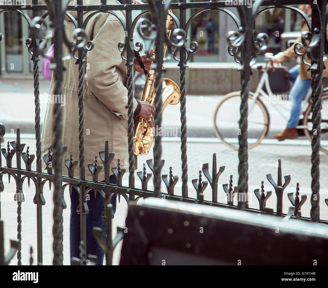 african street musician playing jazz on saxophone throw lattice with ...