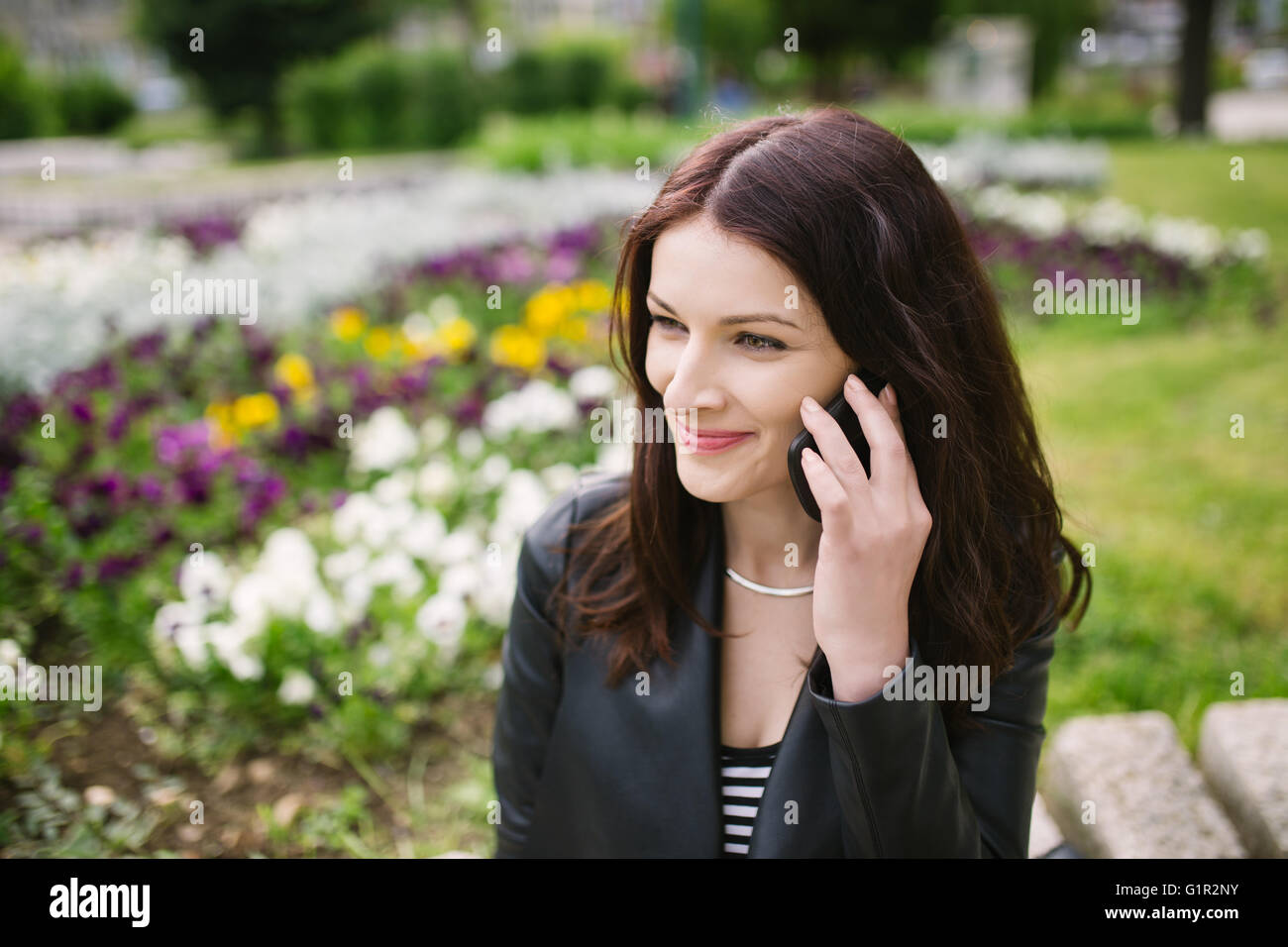 Young woman smiling while talking on the phone Stock Photo - Alamy