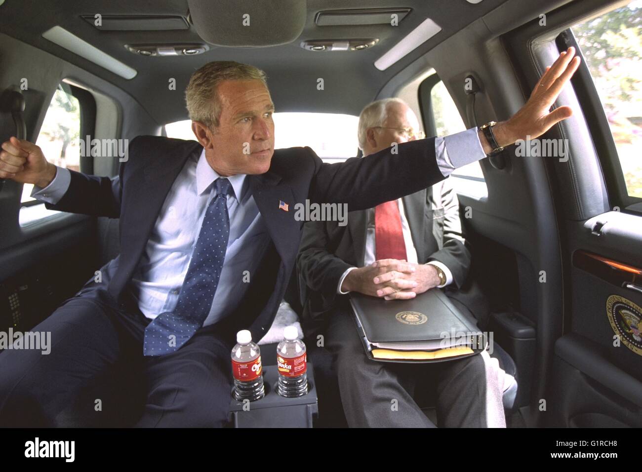 U.S President George W. Bush waves to bystanders as he rides in the ...