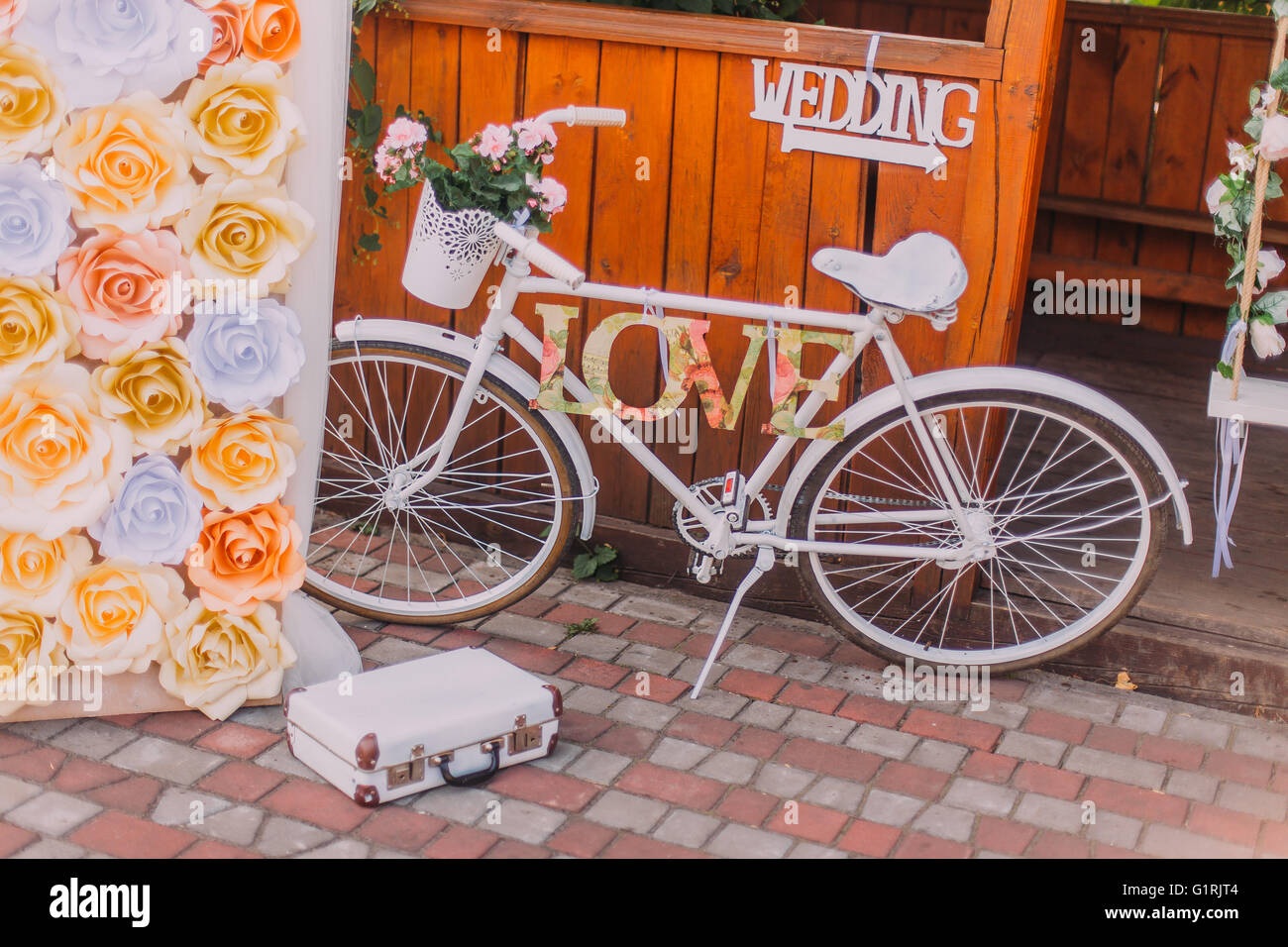 Decorative white bicycle with basket of flowers and word love, indoors ...