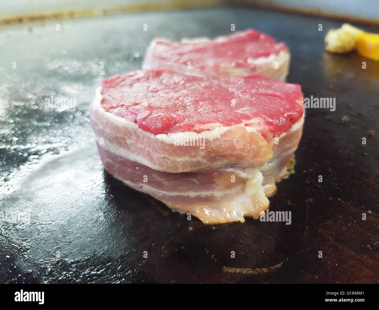 Raw beef, fillet mignon tournedous, wrapped with bacon, getting fried ...