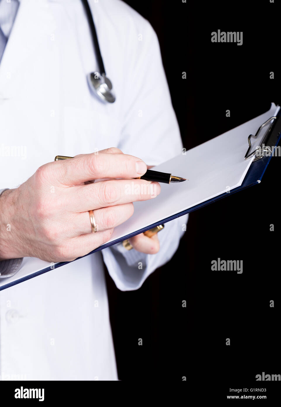 close-up hands of a doctor, he takes notes in a patient's medical ...