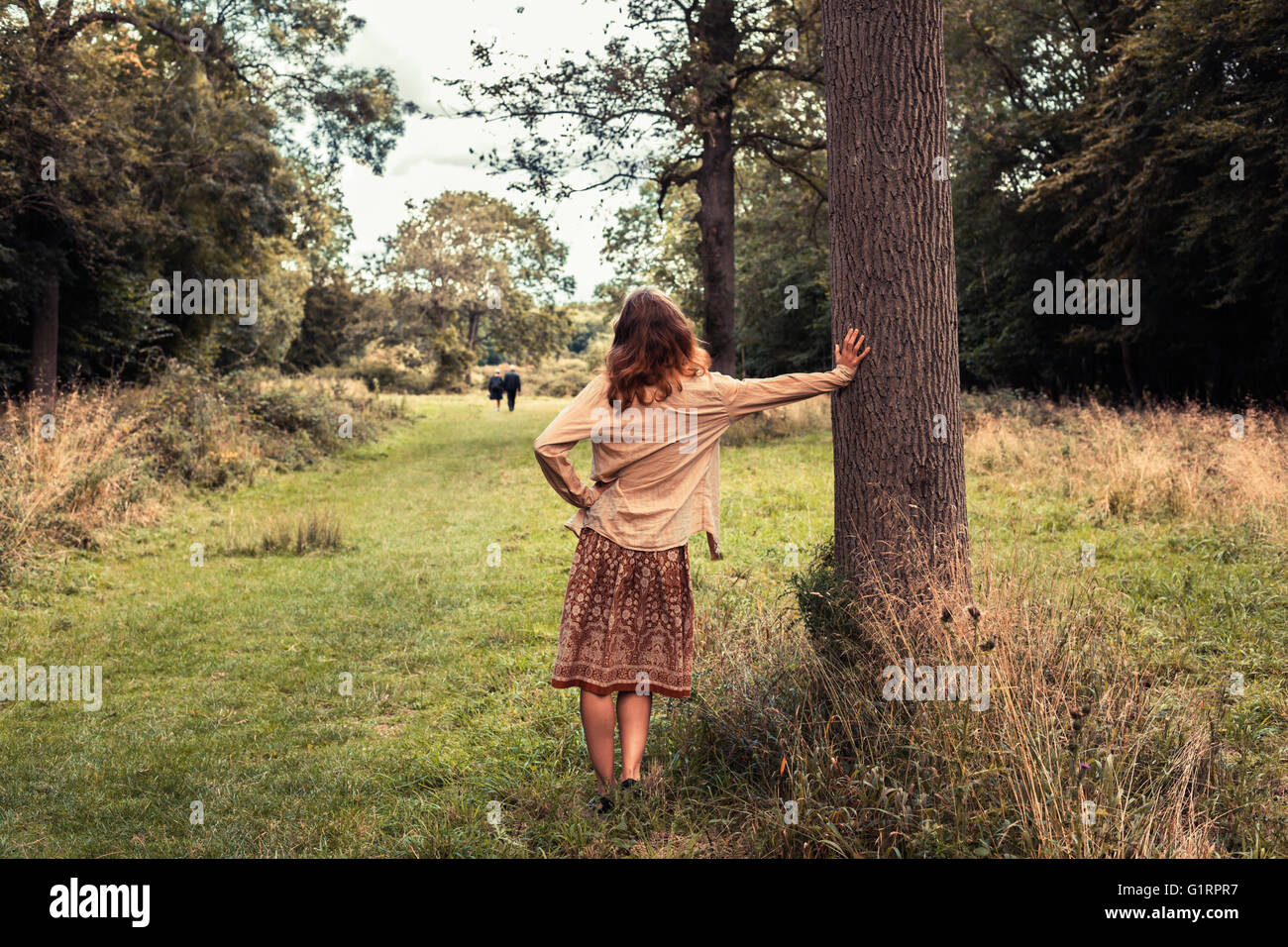 Woman relaxing against tree hi-res stock photography and images - Alamy