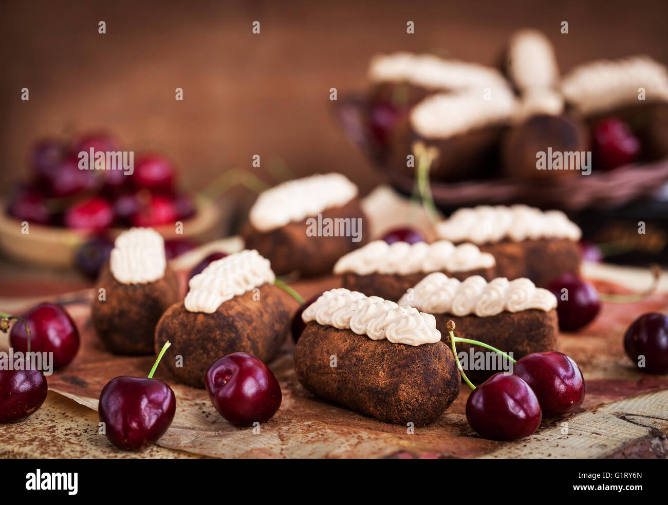 Chocolate rum balls cakes decorated with cream and fresh cherry Stock ...