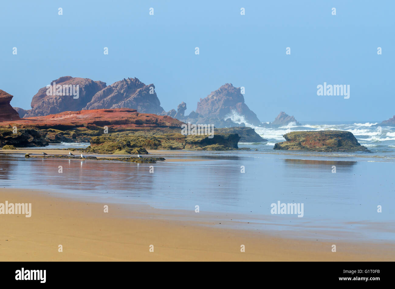 Beautiful beach landscape with big red rocks Stock Photo - Alamy