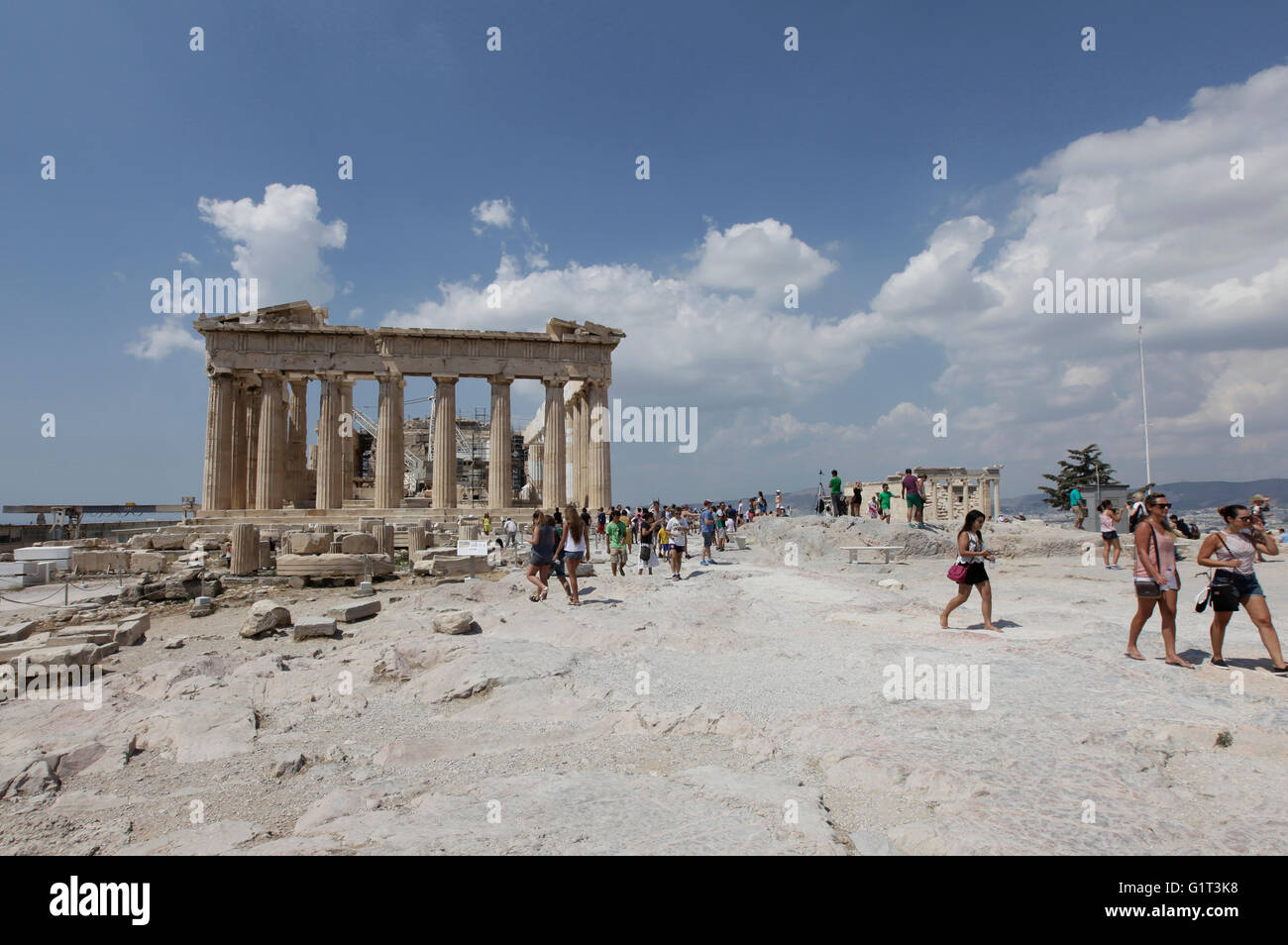 The Parthenon in Athens with tourists taking interest in the ancient ruins at the Athenian ...