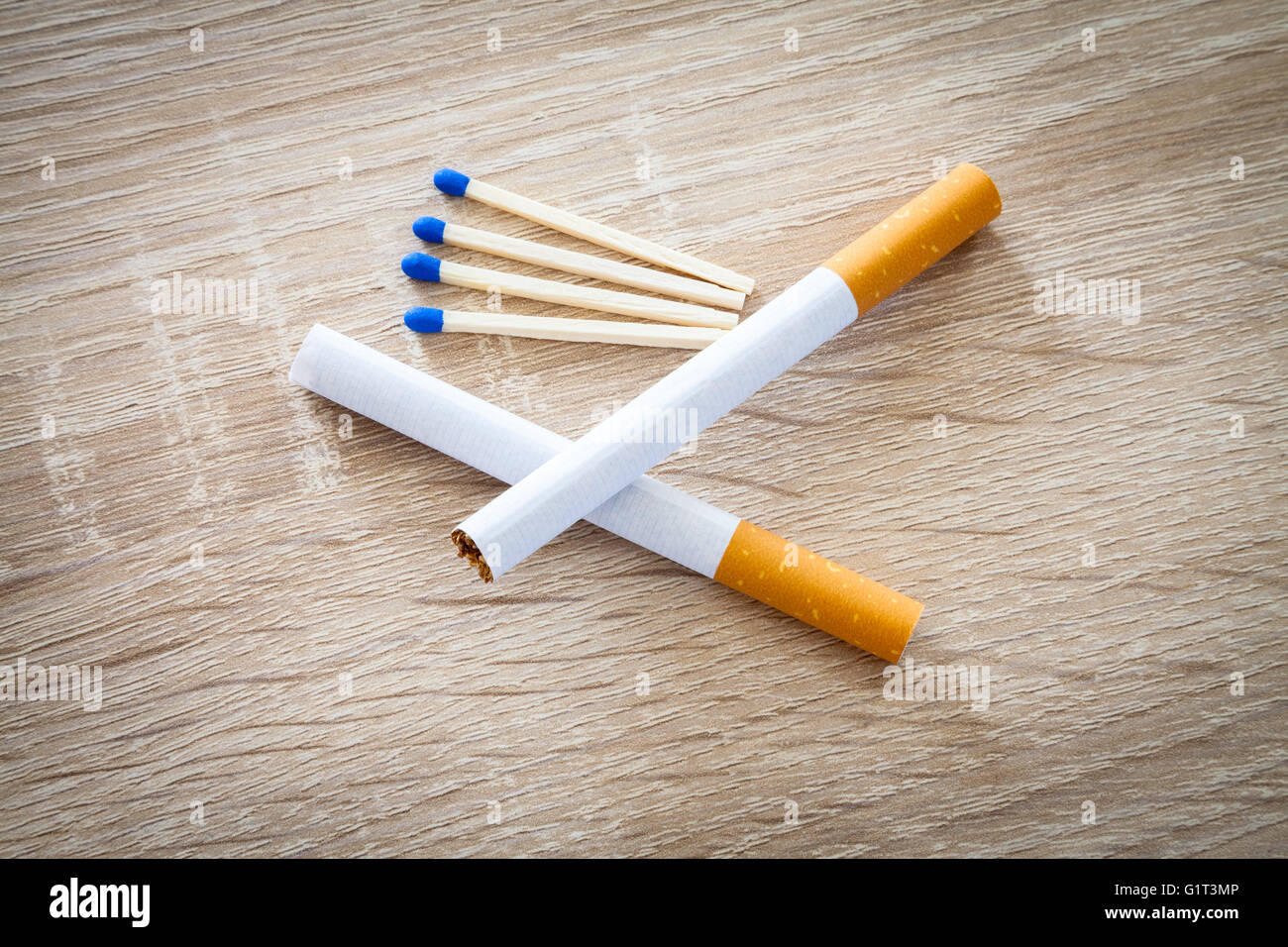 cigarettes and matches on a woody background Stock Photo - Alamy