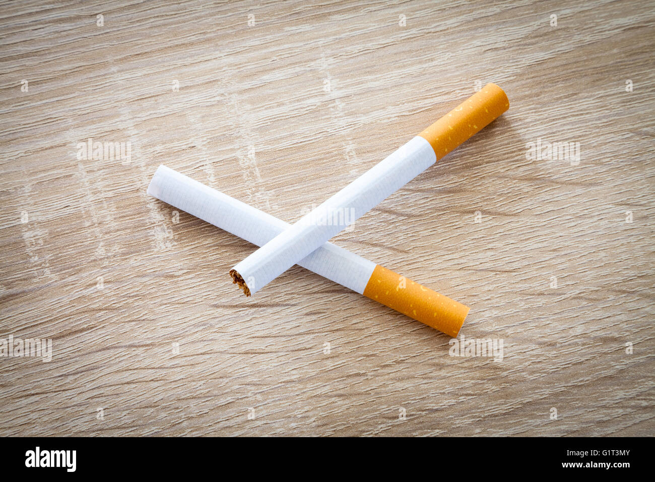 two cigarettes on a woody background Stock Photo - Alamy