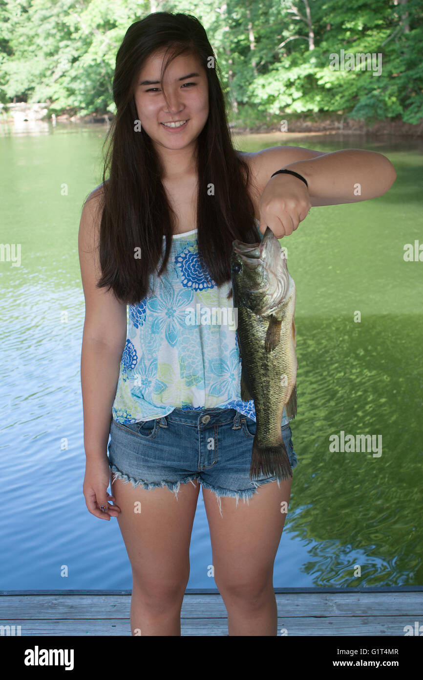 Teenage girl smiling and holding a largemouth bass Stock Photo - Alamy