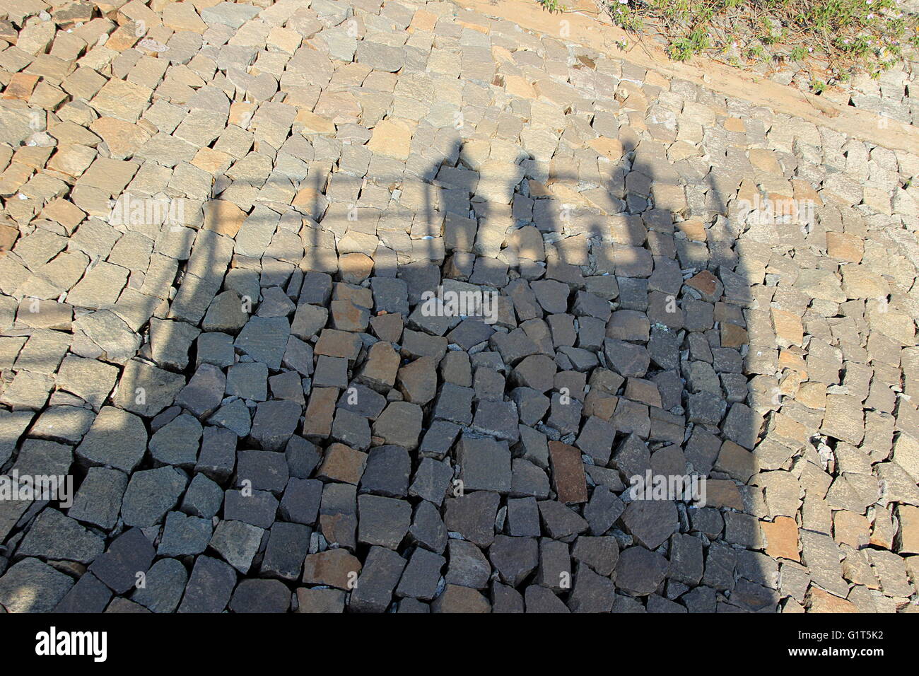 Shadow of watching gallery on sunlit stone pavement below Stock Photo ...