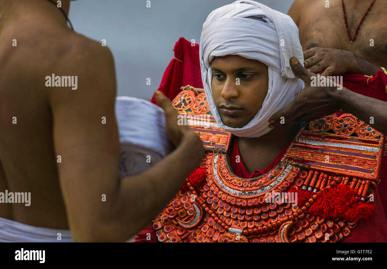 A Theyyam performer is adorned with traditional colourful costume and ...