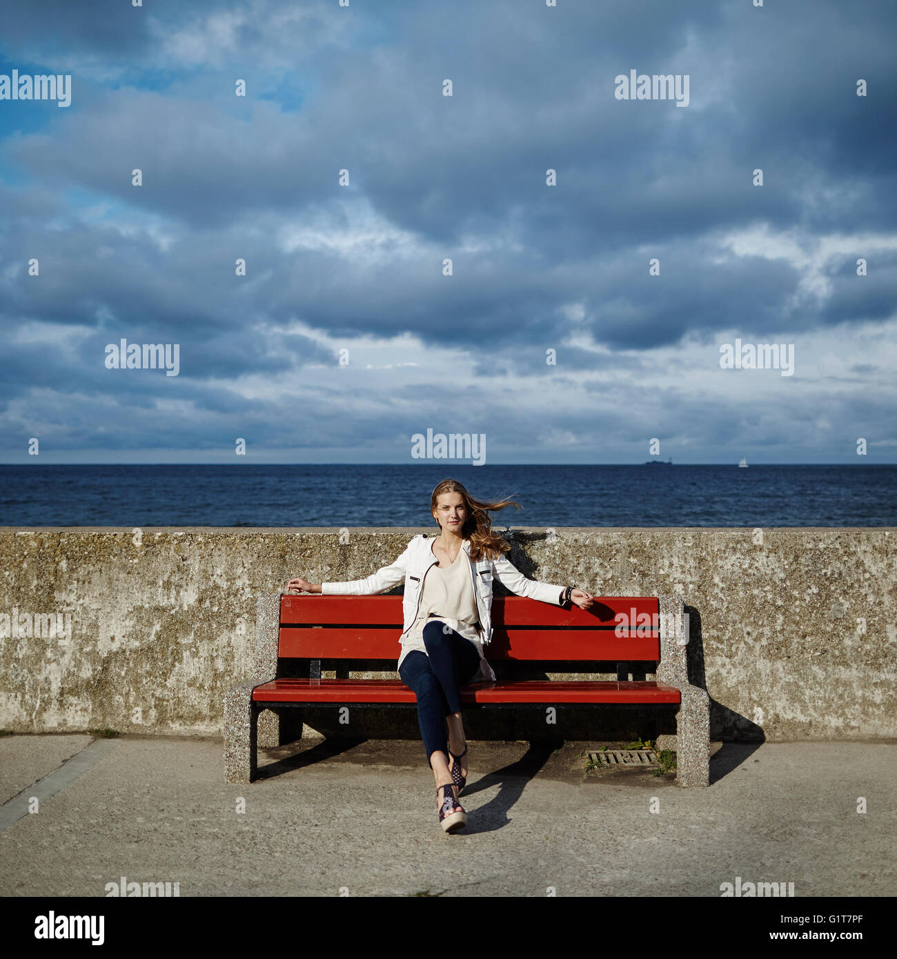 beautiful blonde woman sitting on bench Stock Photo - Alamy