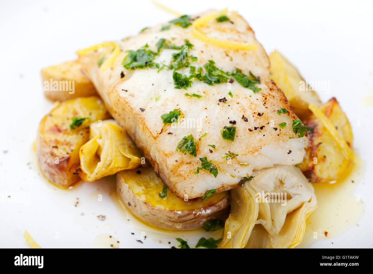 Roasted cod, codfish with baked potatoes and artichokes with lemon and ...