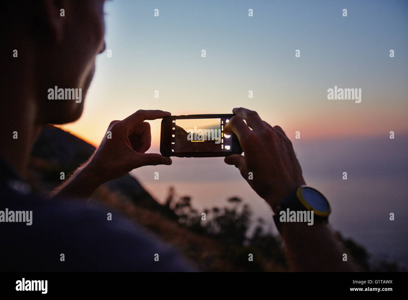 Man photographing sunset ocean view with camera phone Stock Photo - Alamy
