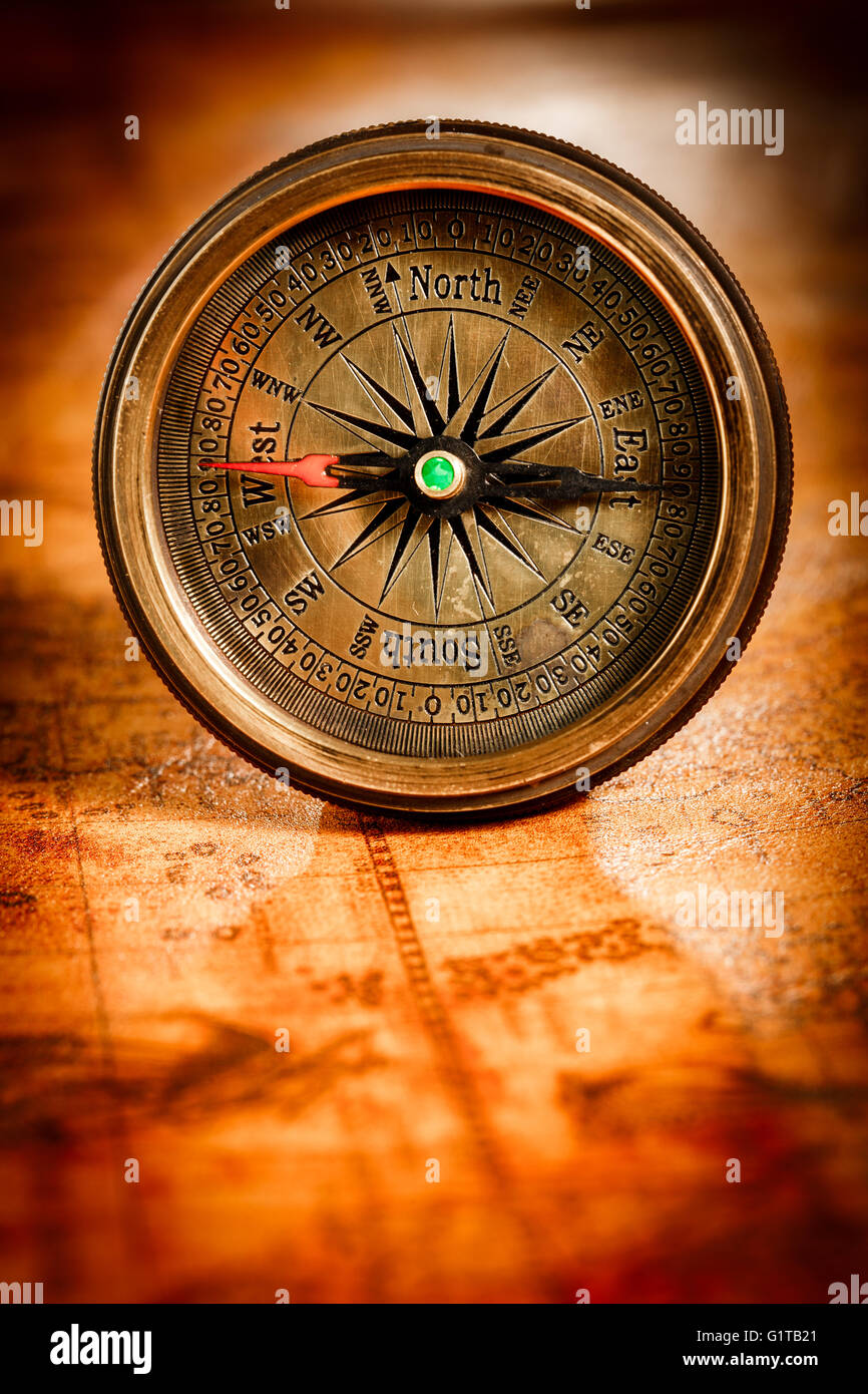 Vintage still life. Vintage compass lies on an ancient world map in ...