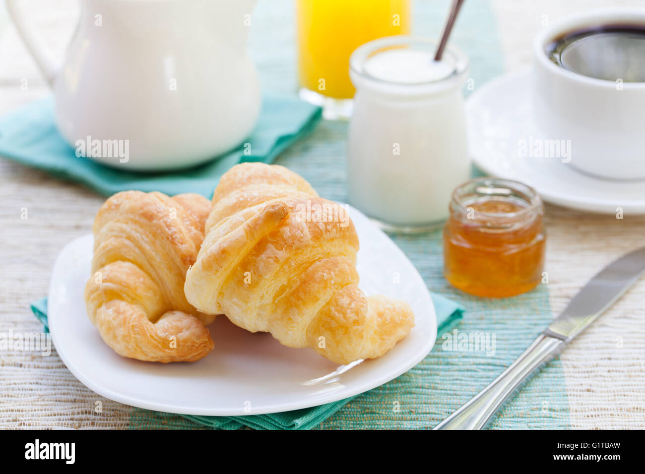 Romantic tropical breakfast Croissants, coffee, juice, honey and yogurt ...