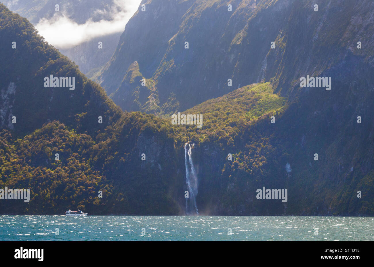 Waterfall flowing down mountain in Milford Sound fjord, Fiordland ...