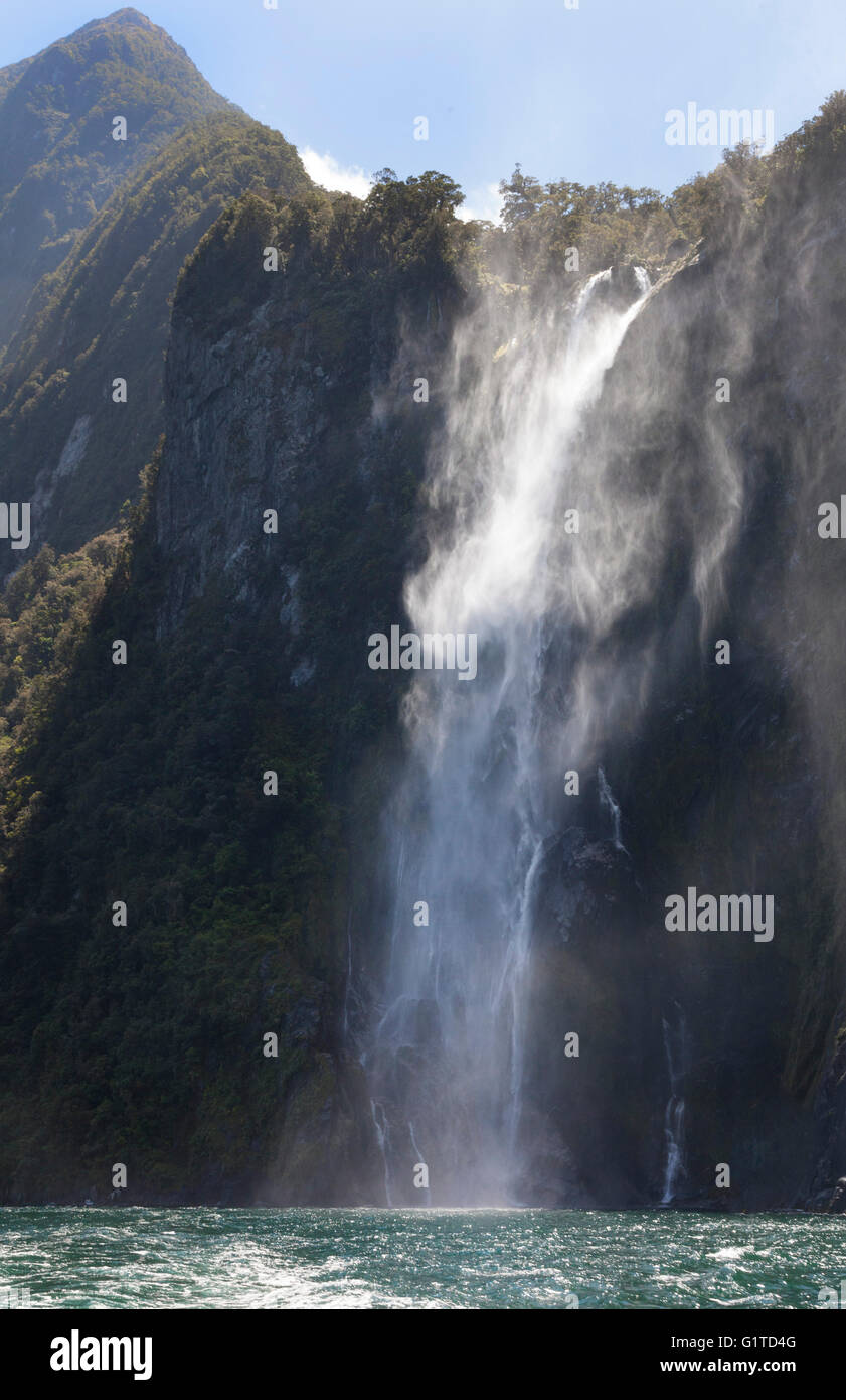 Waterfall flowing down mountain in Milford Sound fjord, Fiordland ...