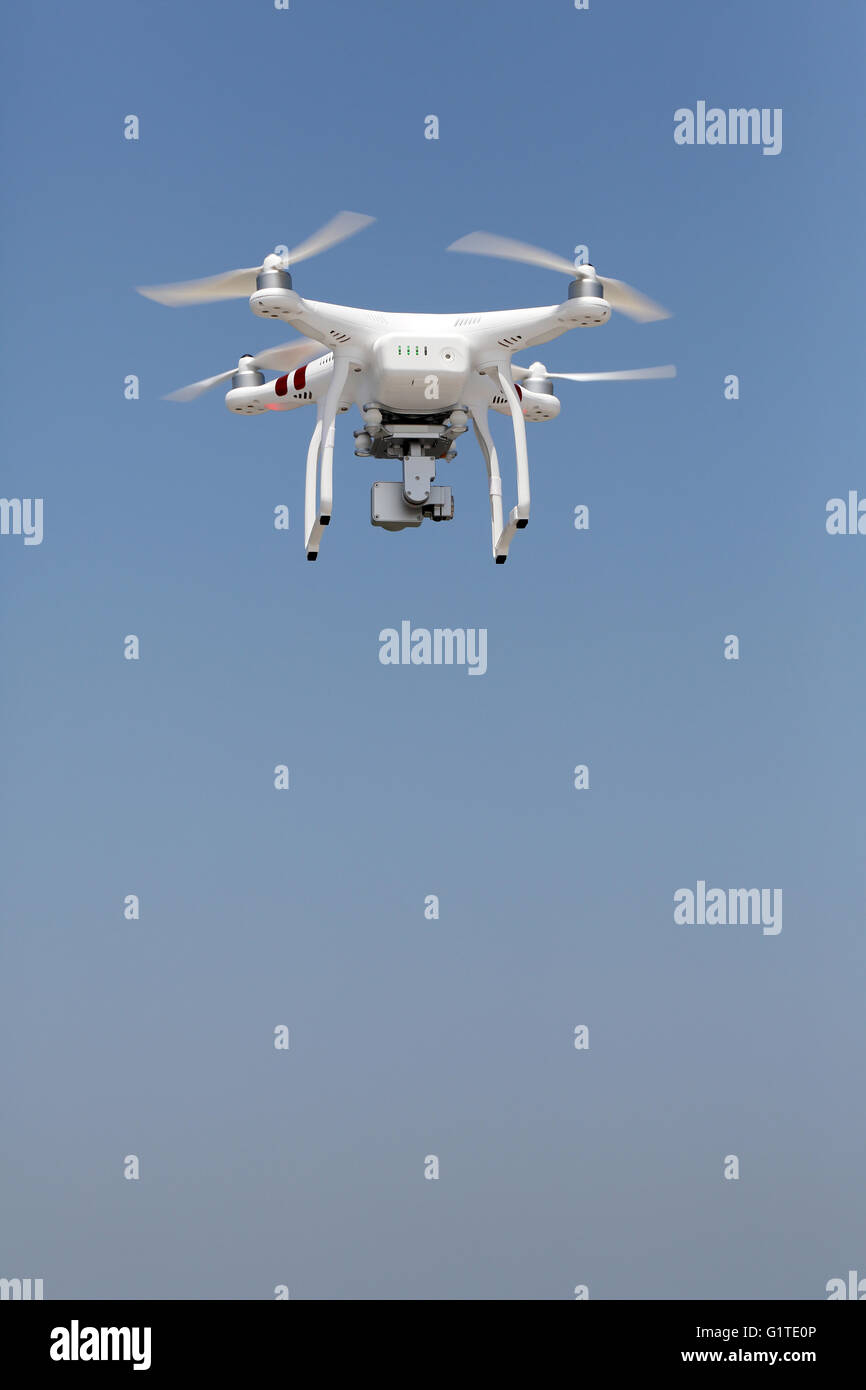 White drone quad copter with flying in the clear blue sky Stock Photo ...