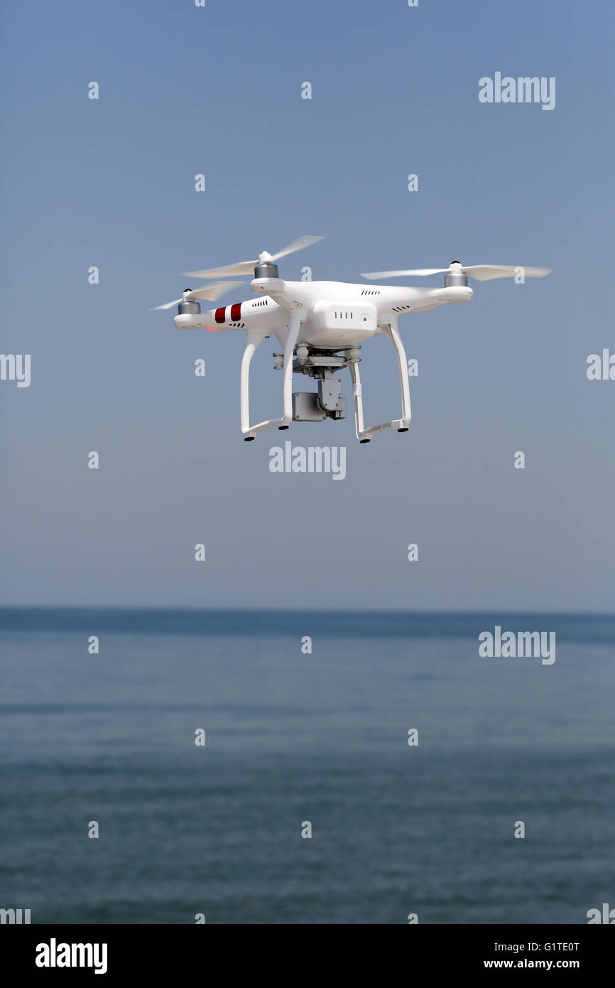 White drone quad copter with flying in the clear blue sky Stock Photo ...