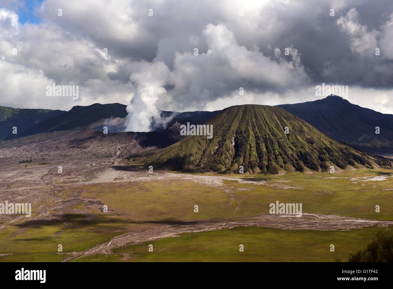 The smoking Gunung Bromo volcano and the Batok volcano rising above the ...