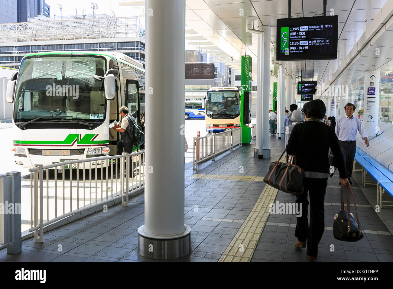 Passengers walk around the departure area of the Shinjuku Expressway ...