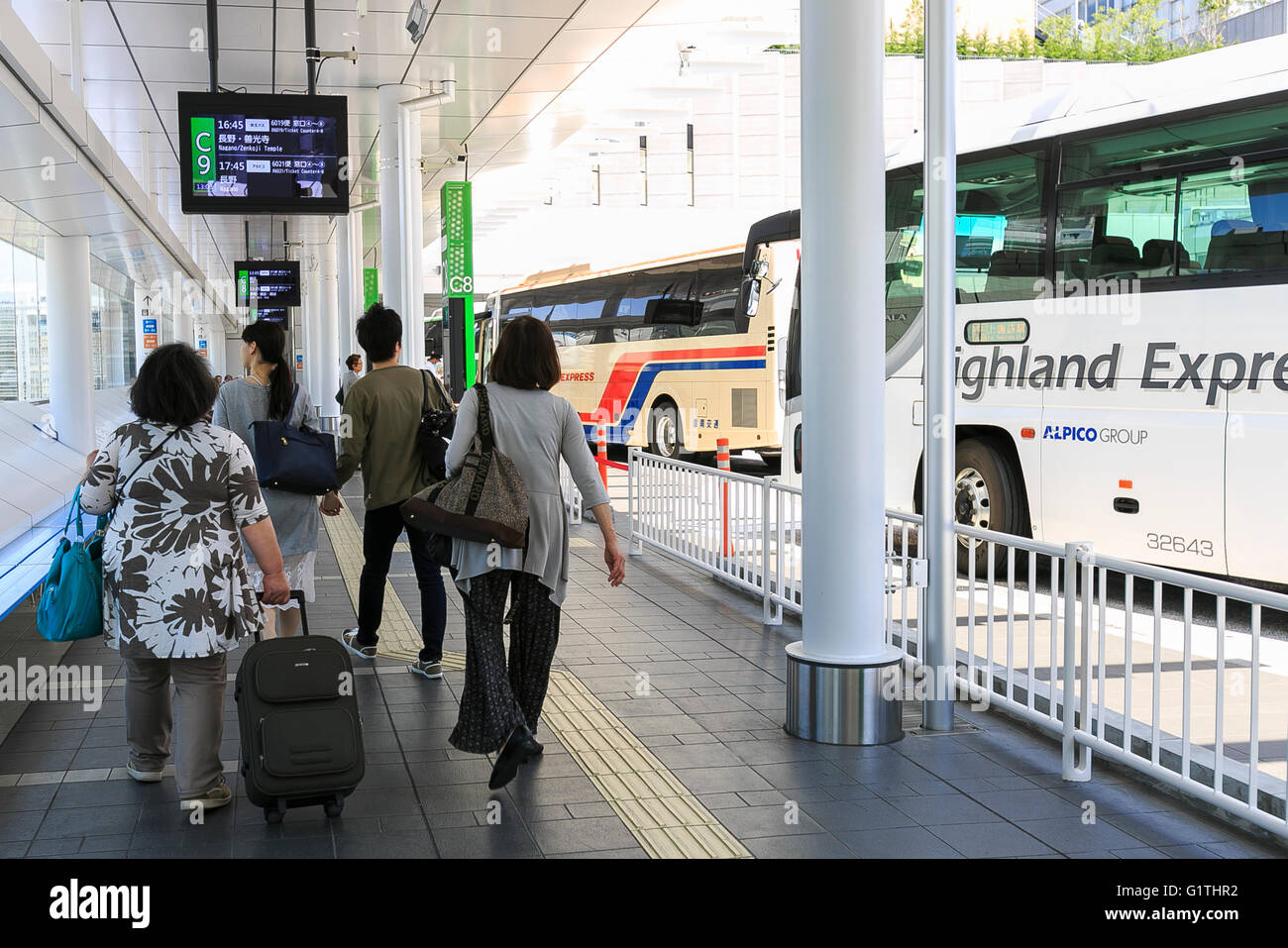 Passengers walk around the departure area of the Shinjuku Expressway ...