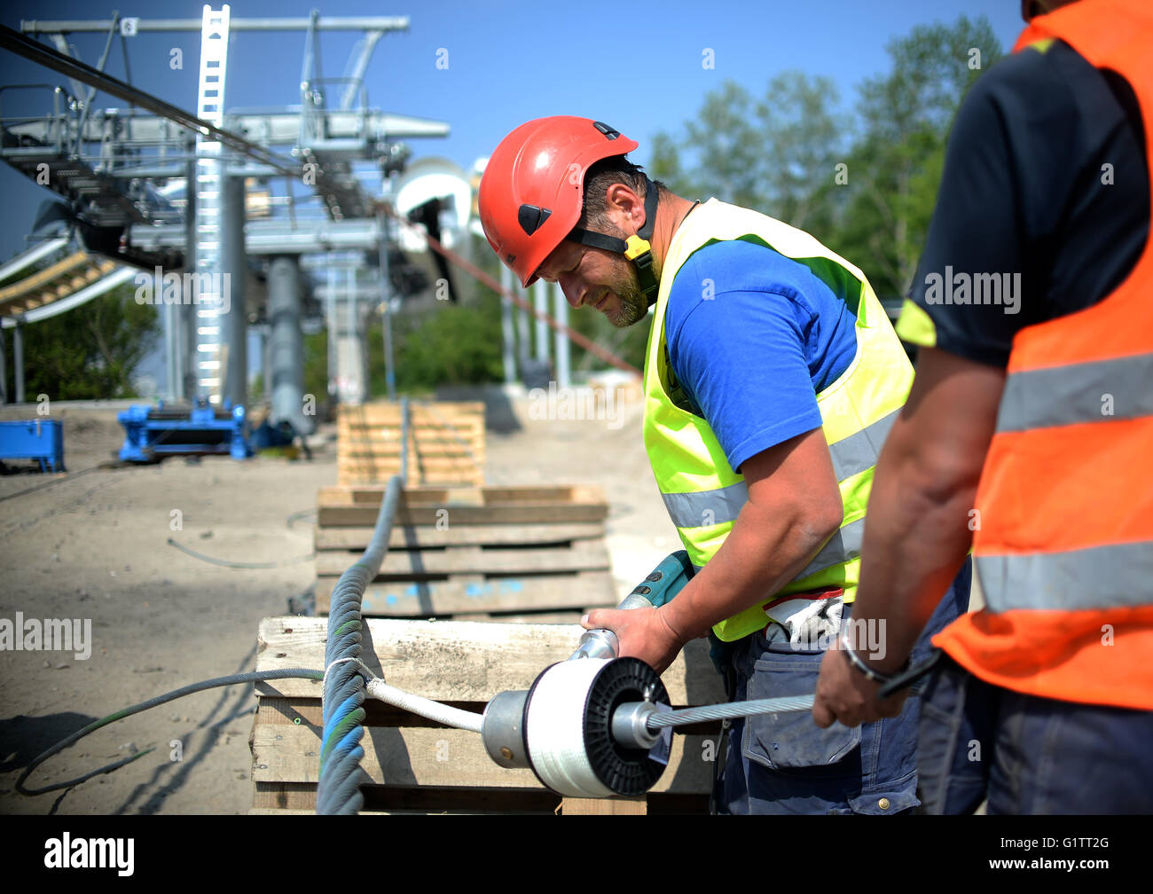Workers splice the control wire for the cable car at the construction ...