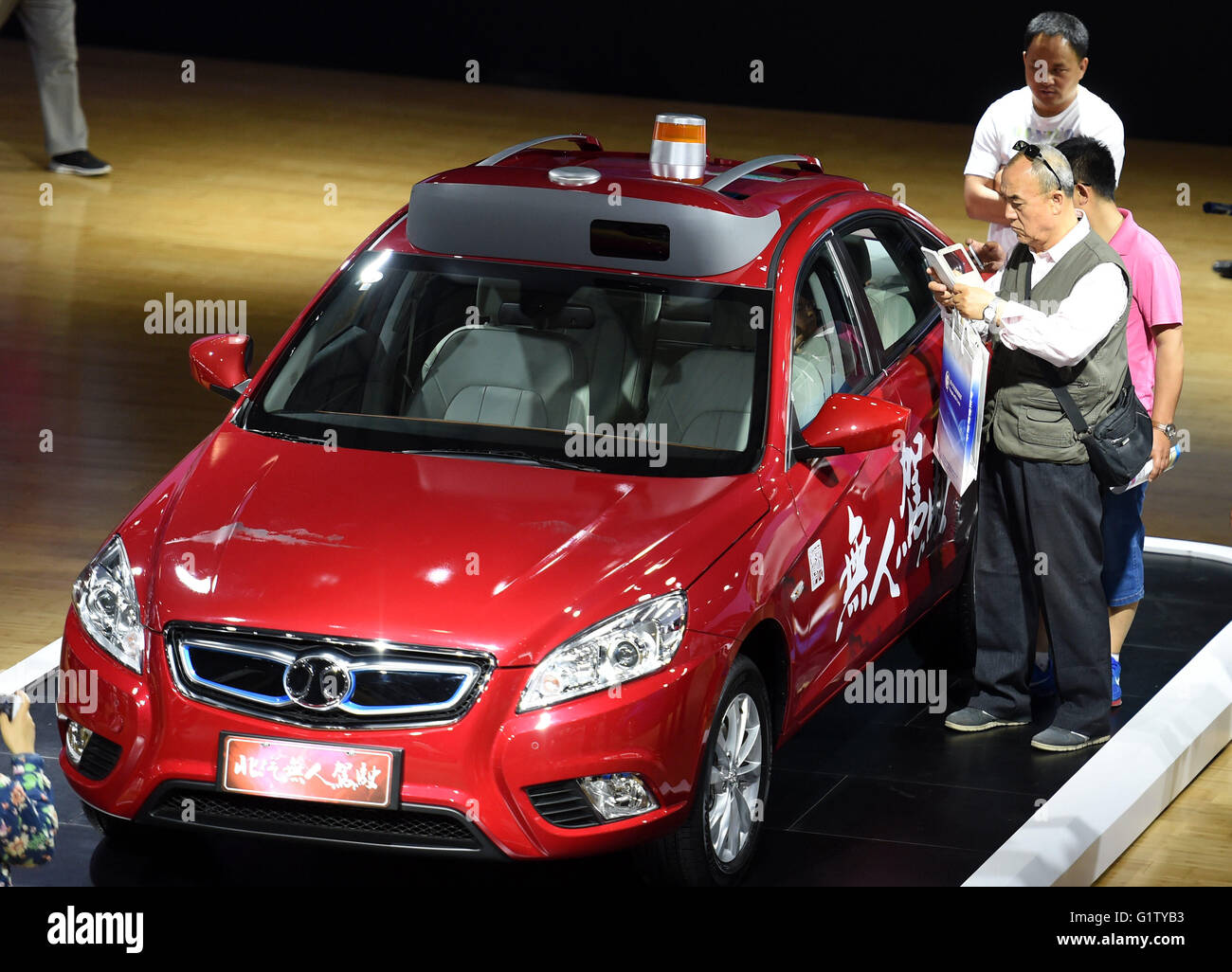 Beijing, China. 20th May, 2016. Visitors look at a driverless car on ...