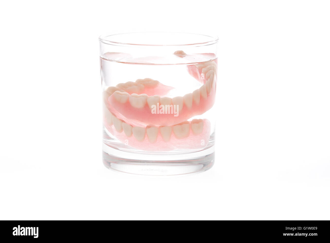 Full Denture in glass of water on white background Stock Photo - Alamy
