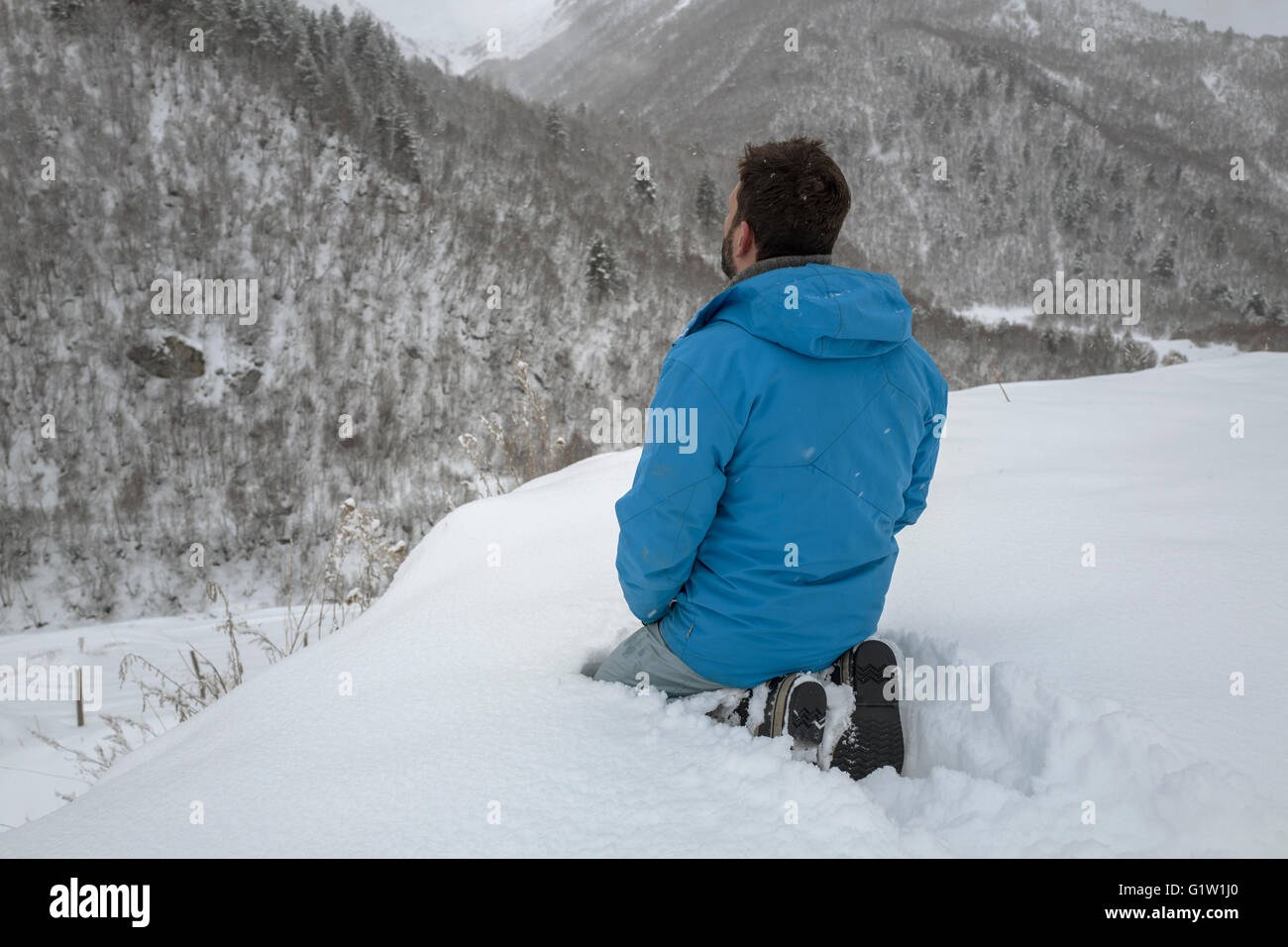 Man is praying seating in the snow around of mountains Stock Photo - Alamy