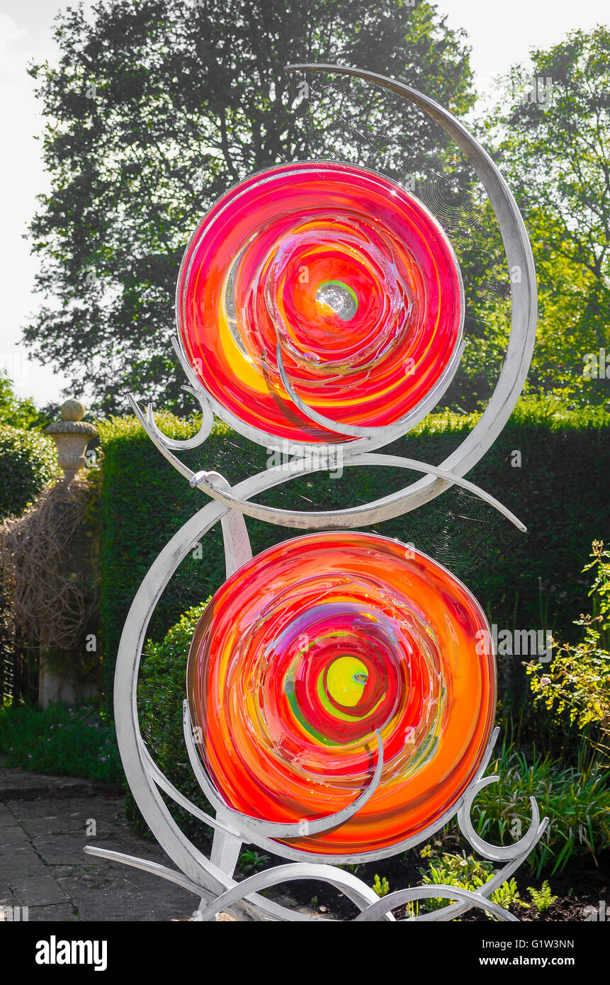 Two glass discs form focal points on a modern piece of garden sculpture ...