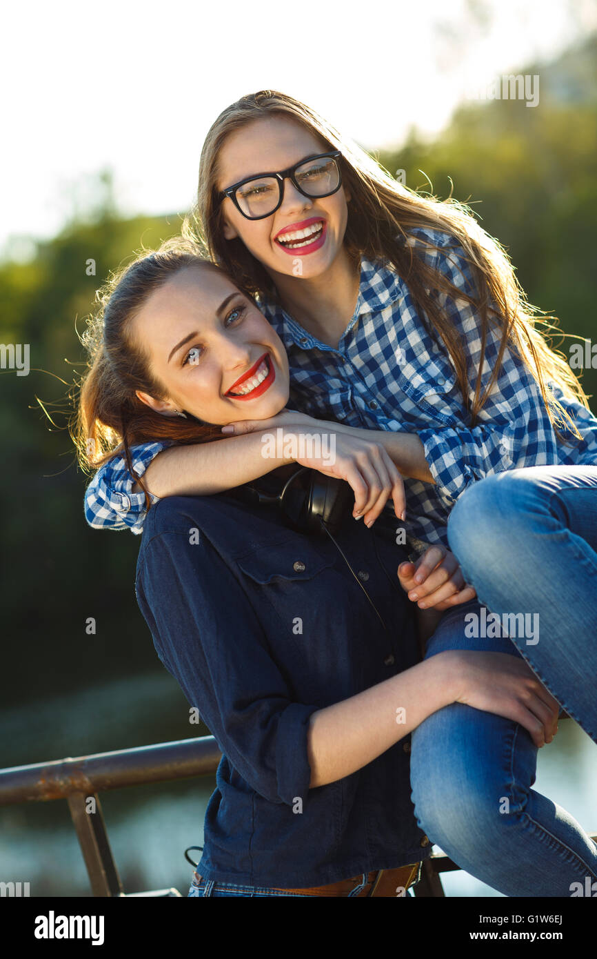 Two playful young women having fun outdoors at sunset light Stock Photo - Alamy