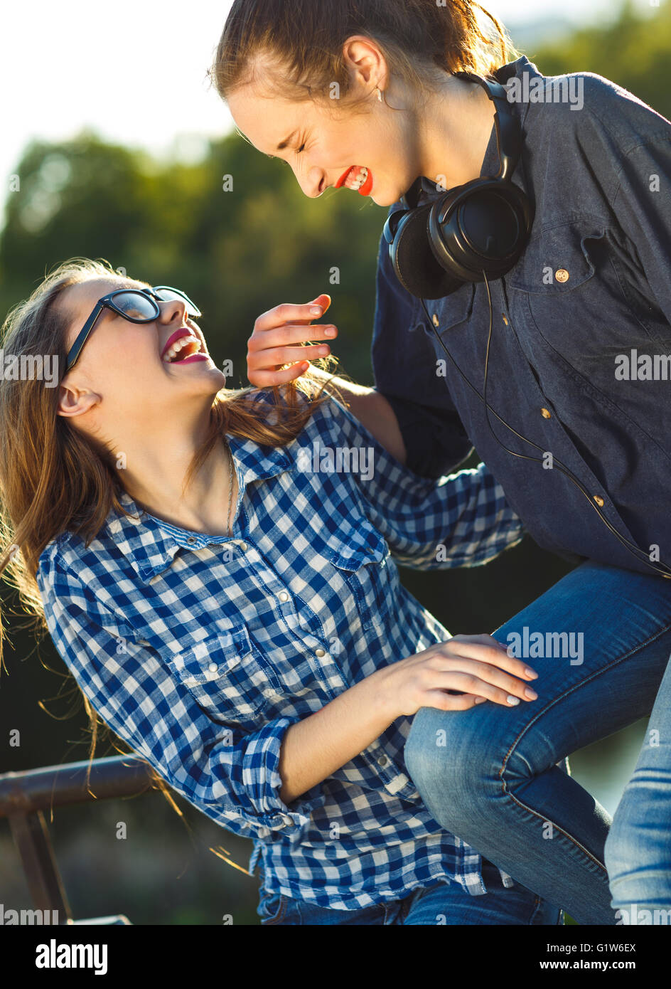 Two playful young women having fun outdoors at sunset light Stock Photo ...