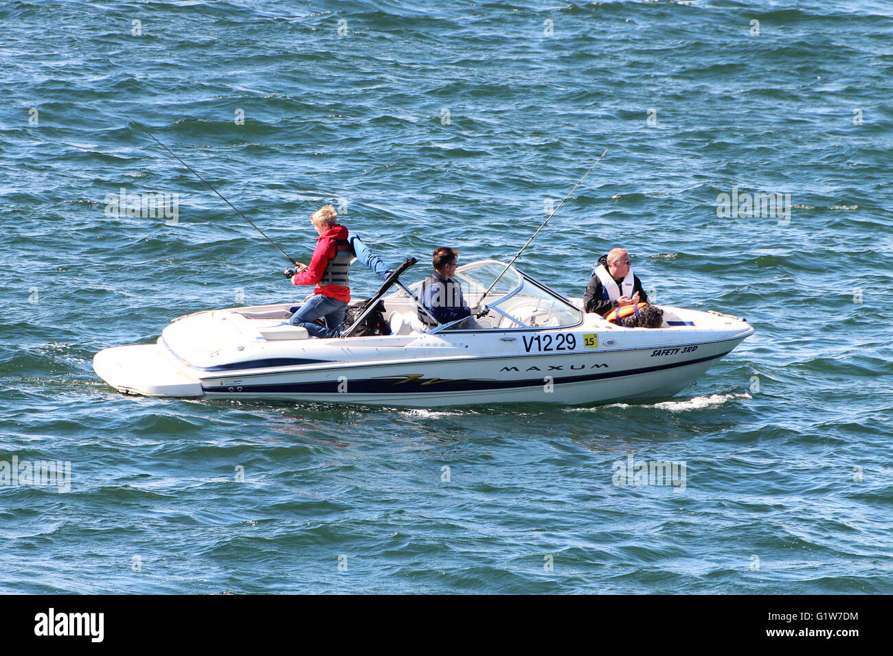 The occupants of a small powerboat /motorboat carry out a spot of sea ...