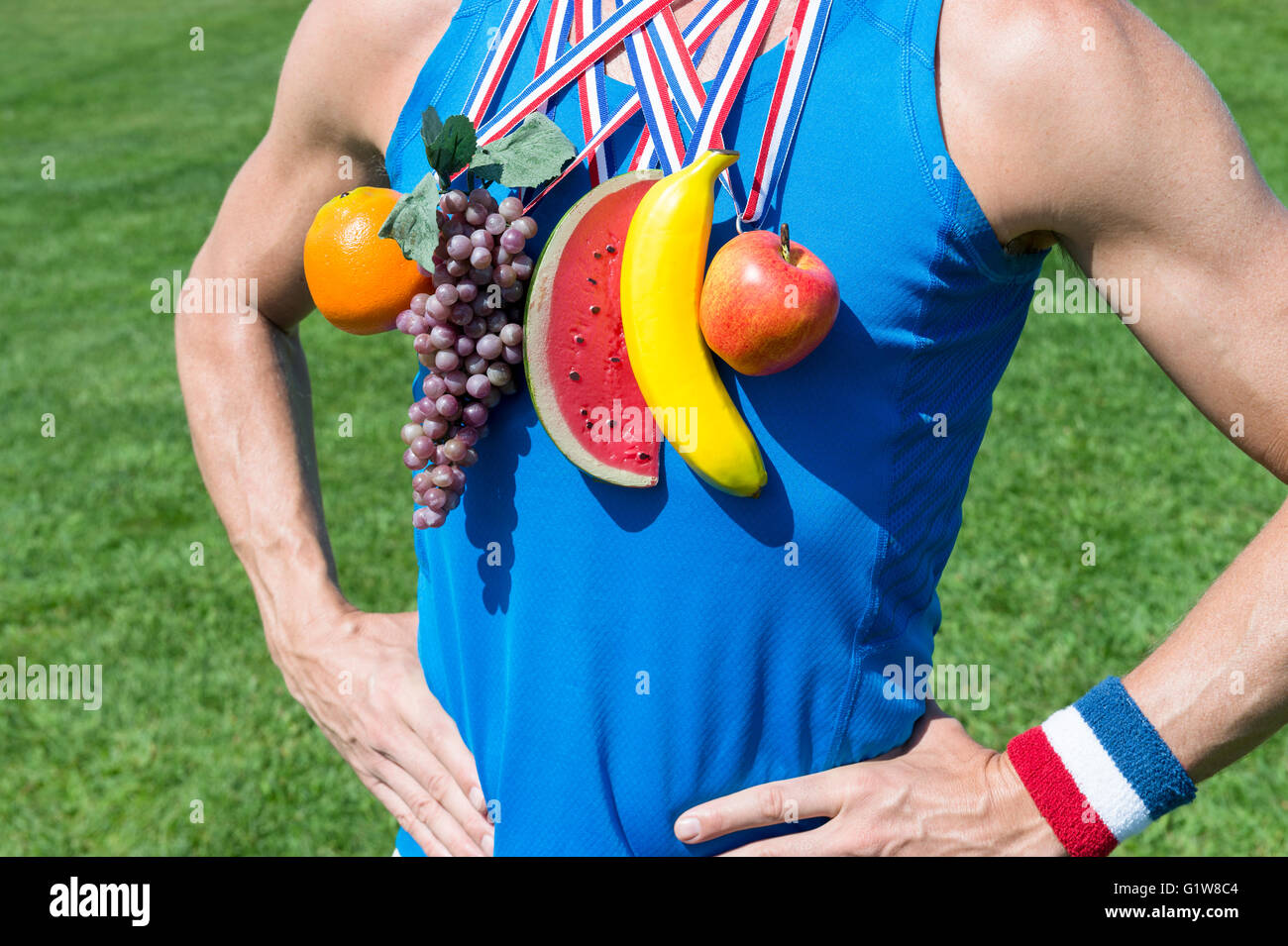 Winner of healthy eating competition standing with fruit medals ...