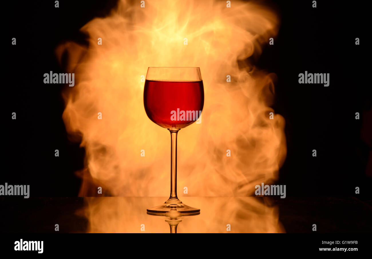single glass with red wine on fire background isolated black Stock ...