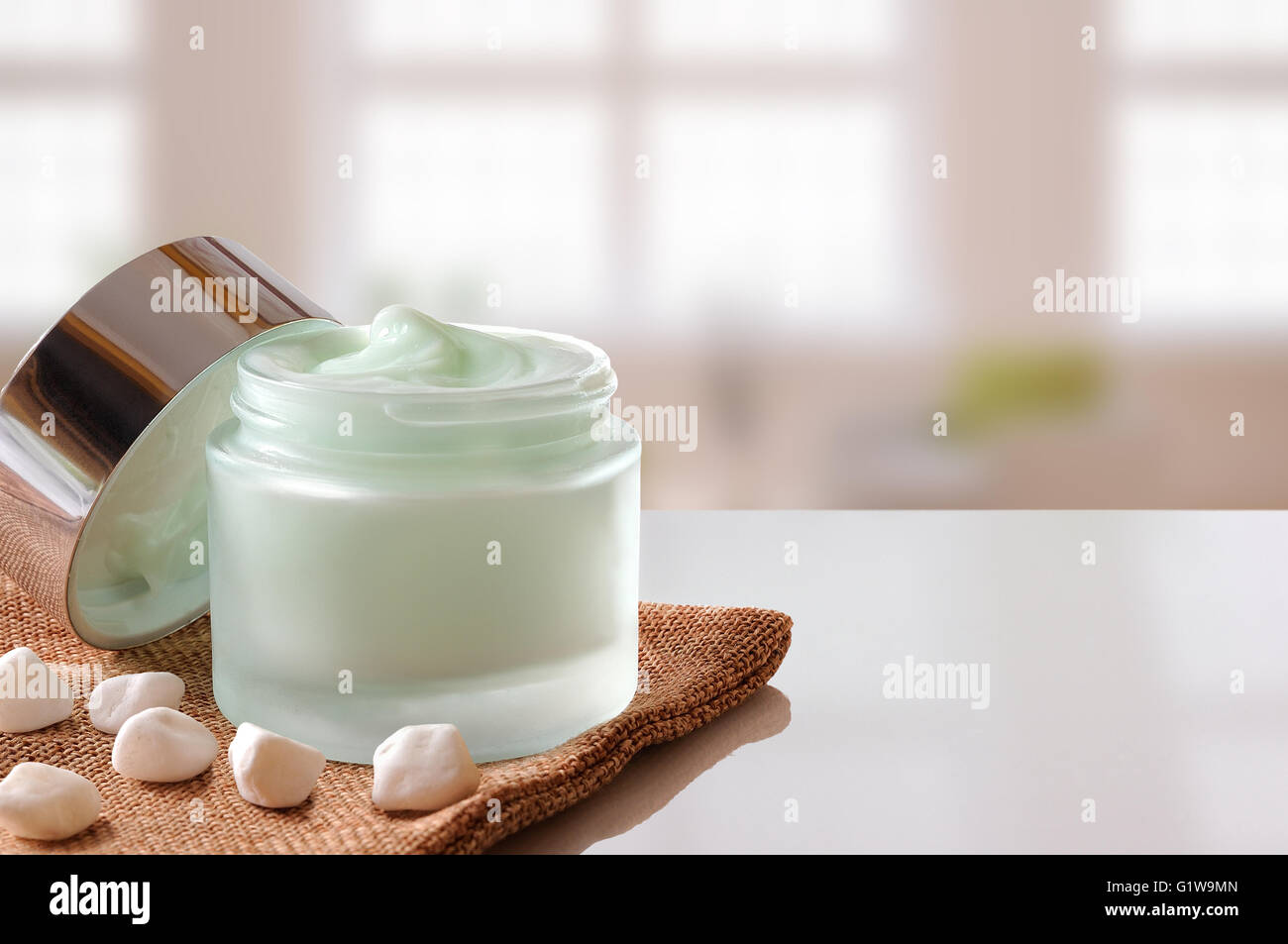 Glass open jar with facial or body cream on burlap. with lid and small ...