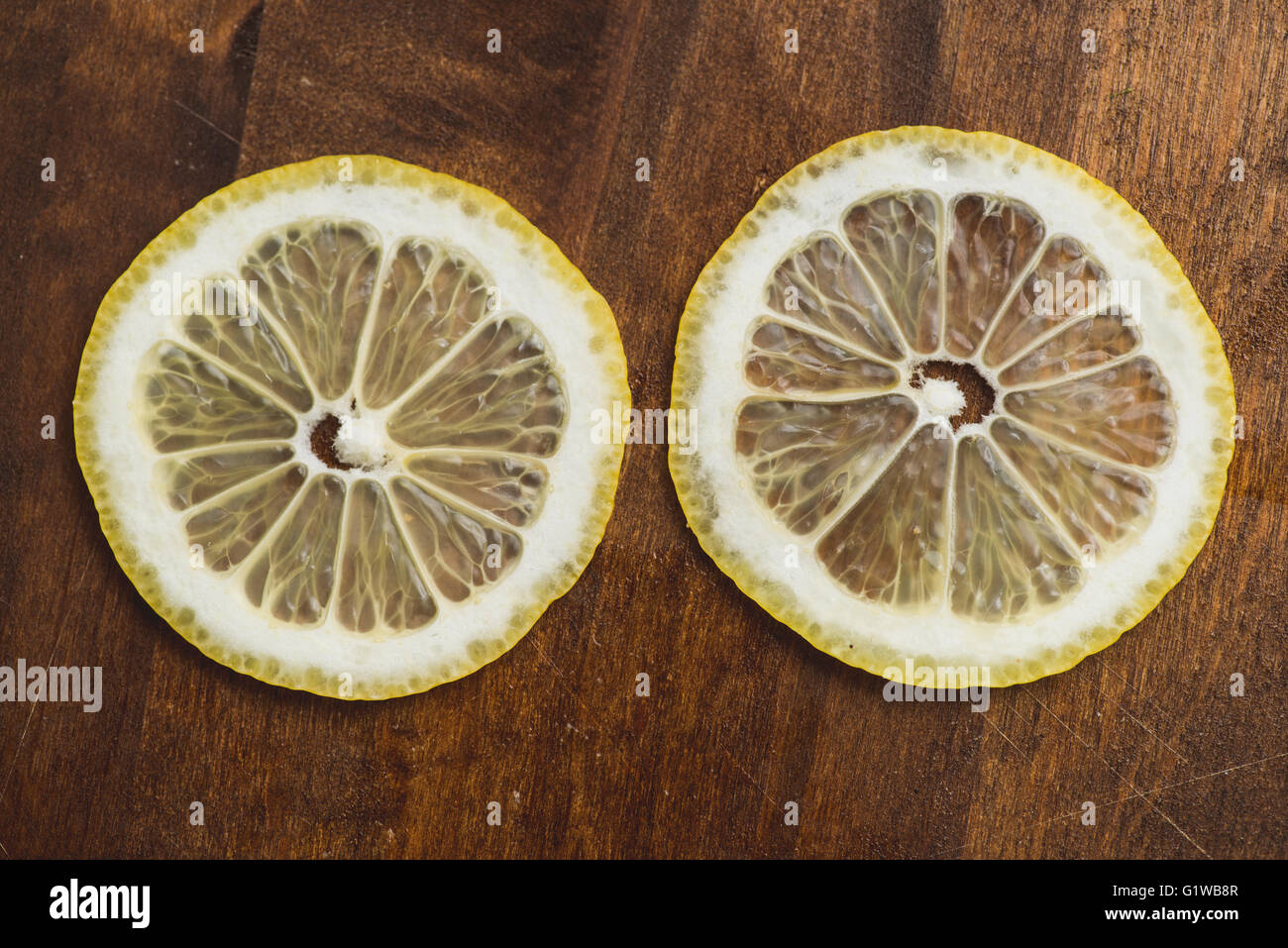 two thin slices Fresh Lemon on Wood Table Background, Rustic Style ...