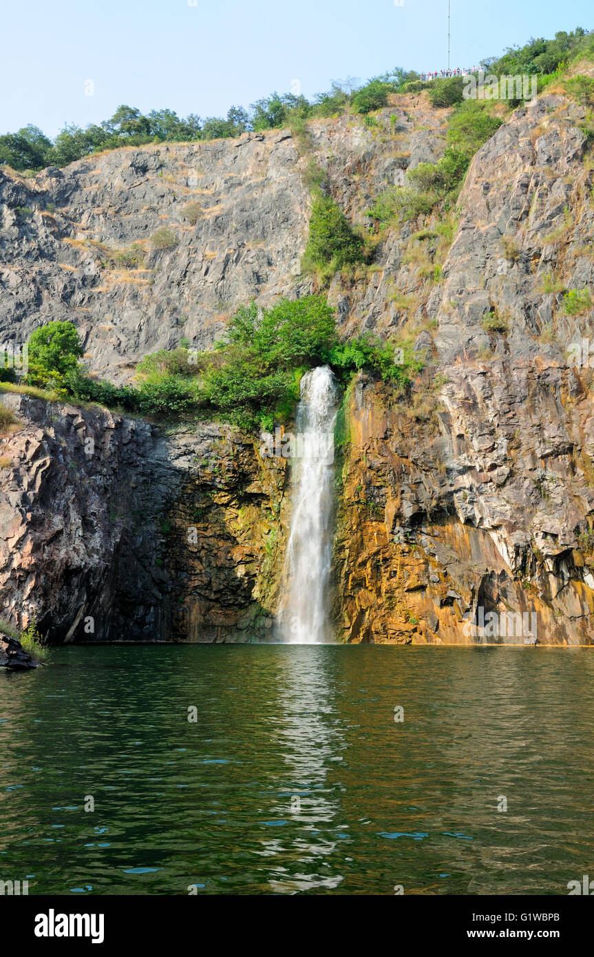 A waterfall flowing into the rock quarry at Chenshan Botanical Gardens ...
