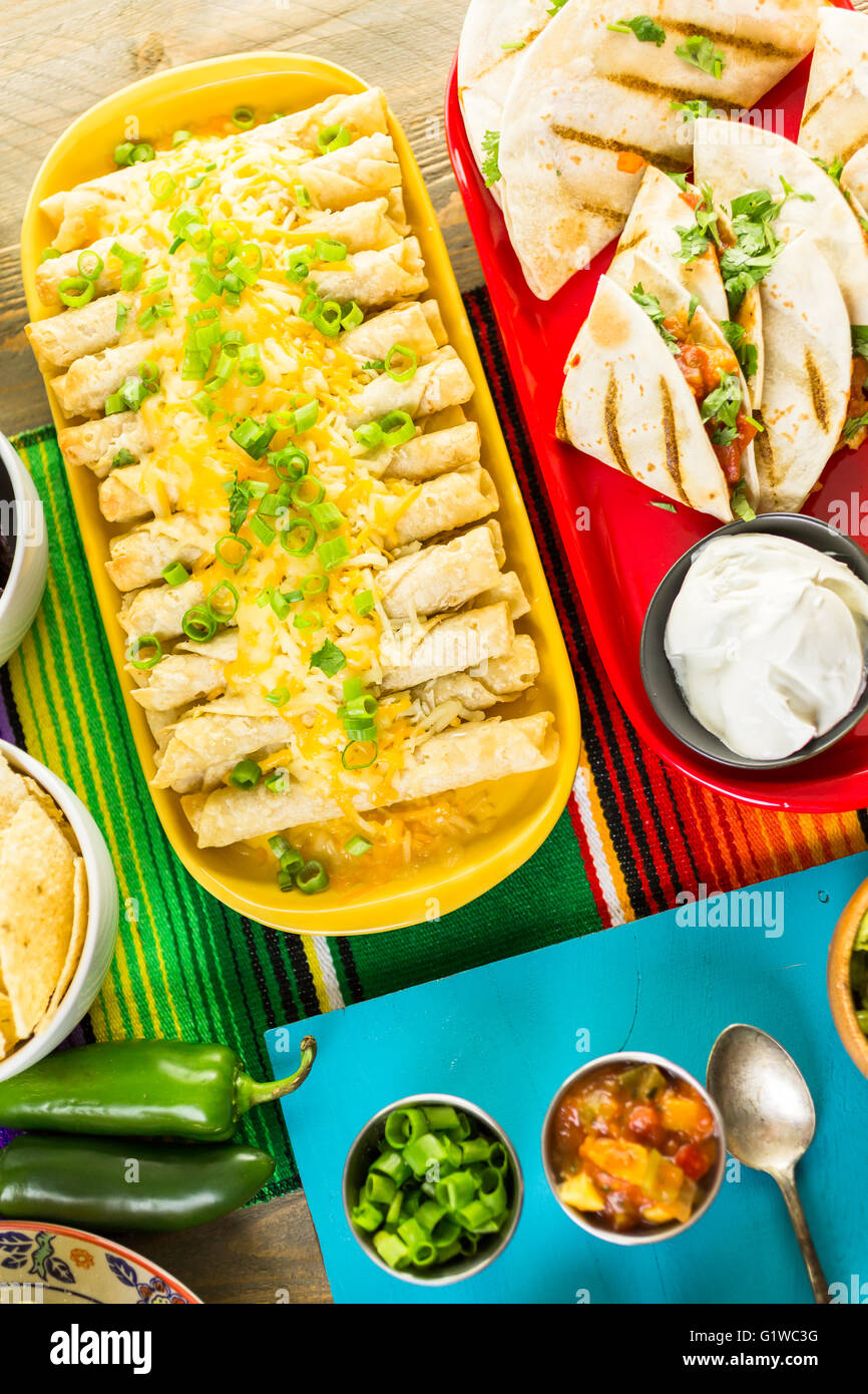 Fiesta party buffet table with chicken taquitos and other traditional ...