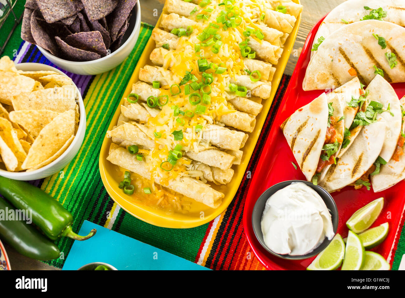 Fiesta party buffet table with chicken taquitos and other traditional ...