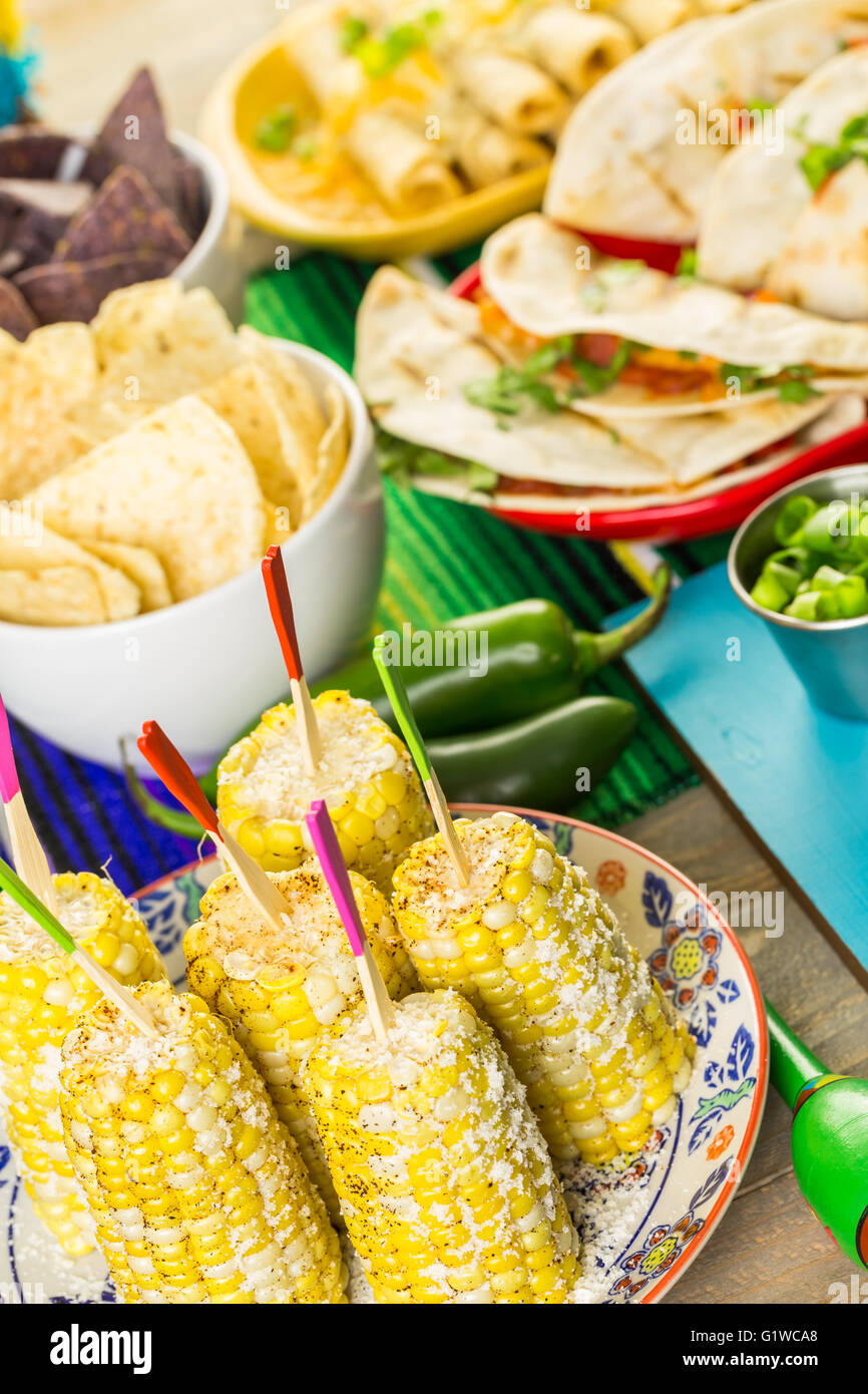 Fiesta party buffet table with spicy mexican corn on the cob and other ...