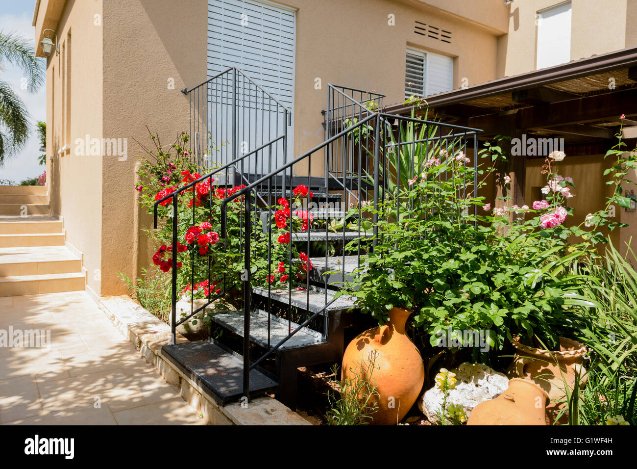 Detail courtyard with metal steps and roses around Stock Photo - Alamy