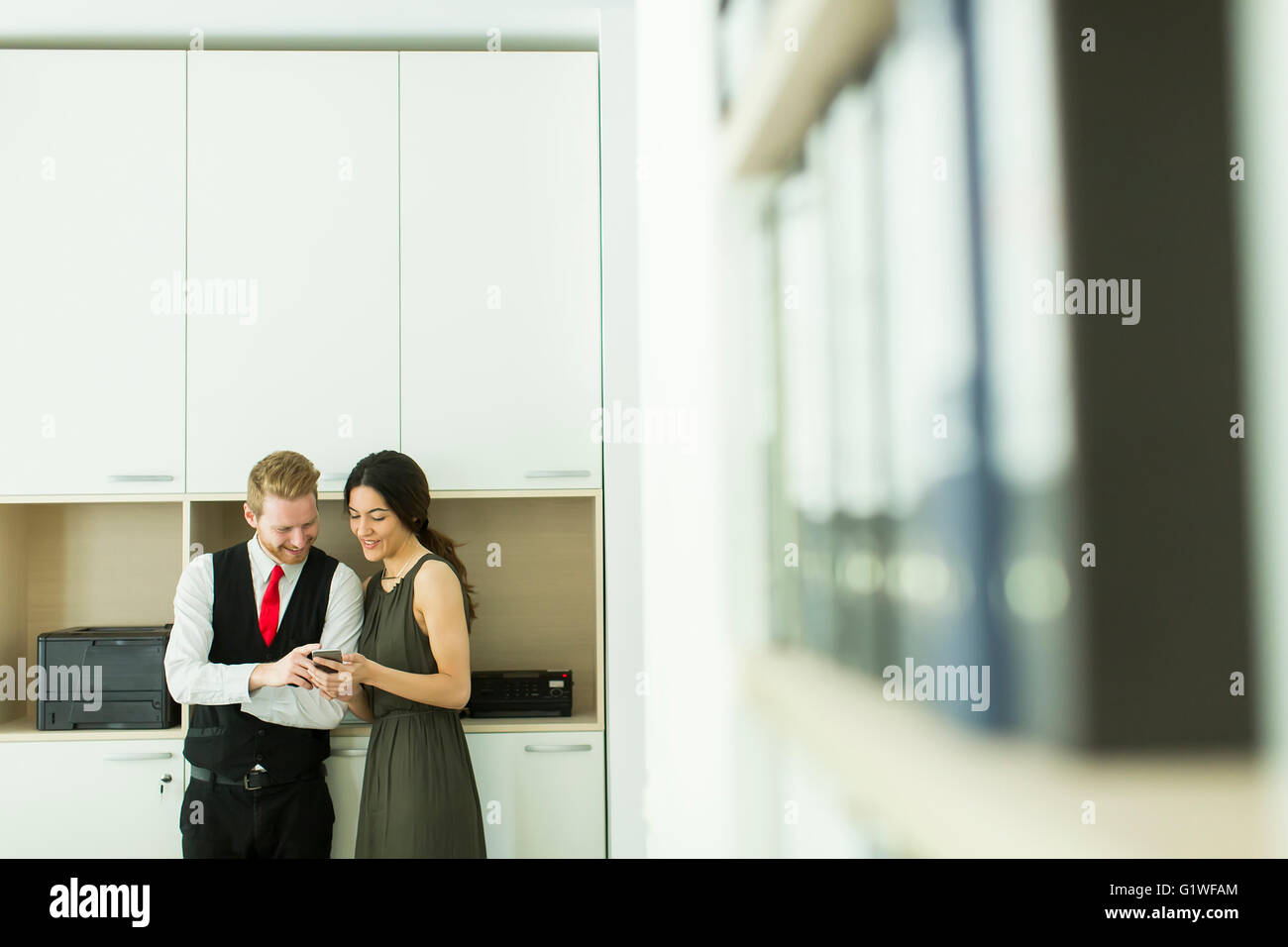 People looking at the phone in the office Stock Photo - Alamy