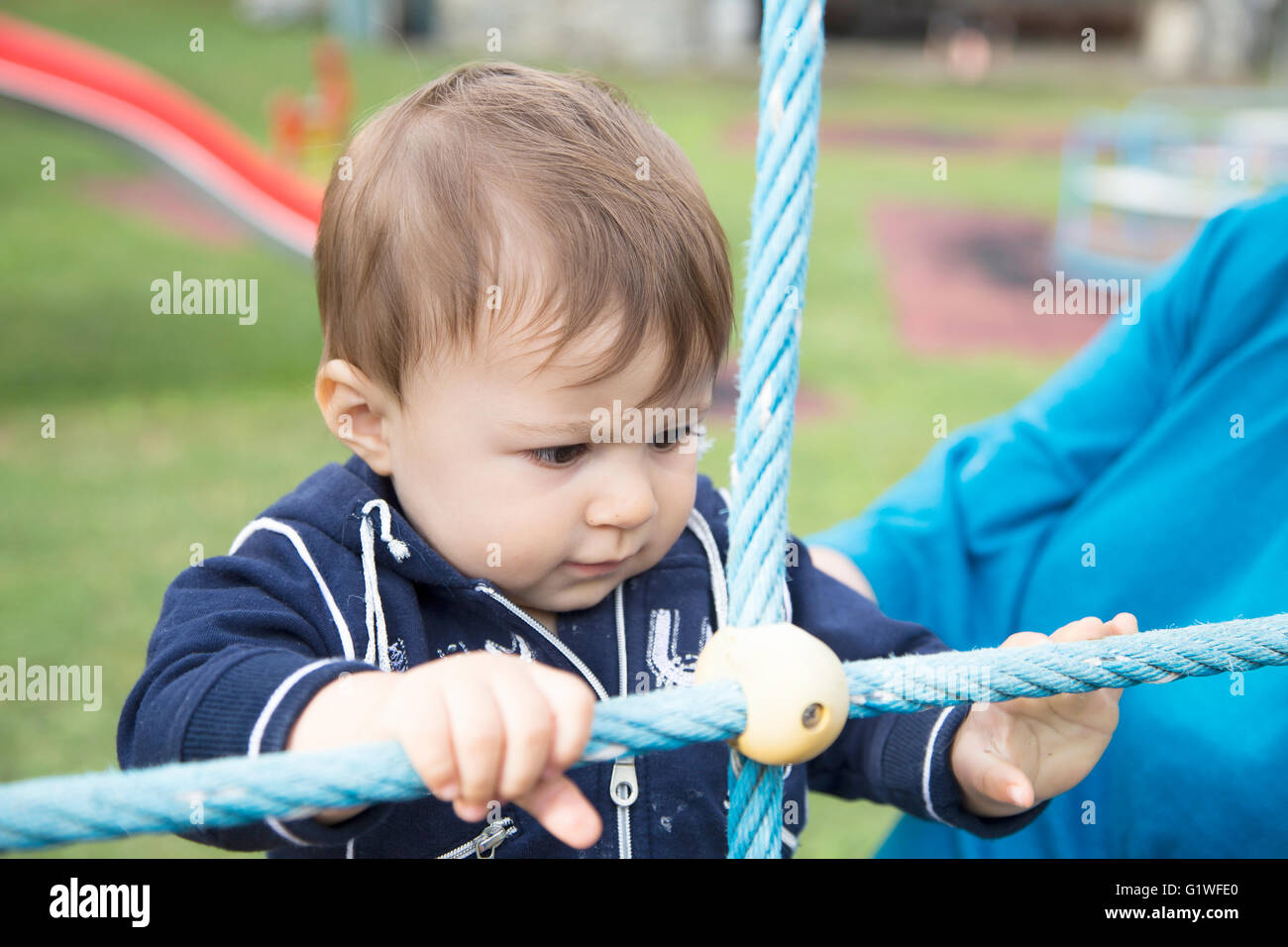 Portrait of little cute one year old baby holding blue ropes Stock ...