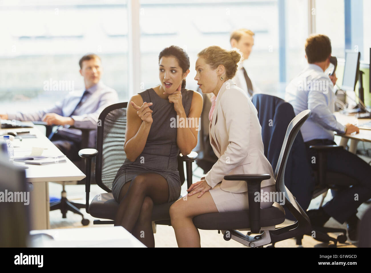 Businesswomen gossiping in office Stock Photo - Alamy