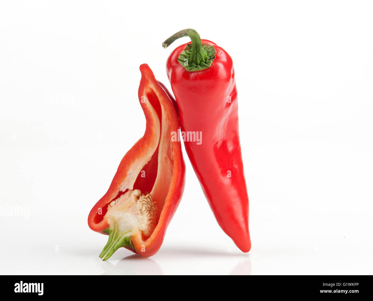 two red capia pepper, one whole and one half, isolated on white ...