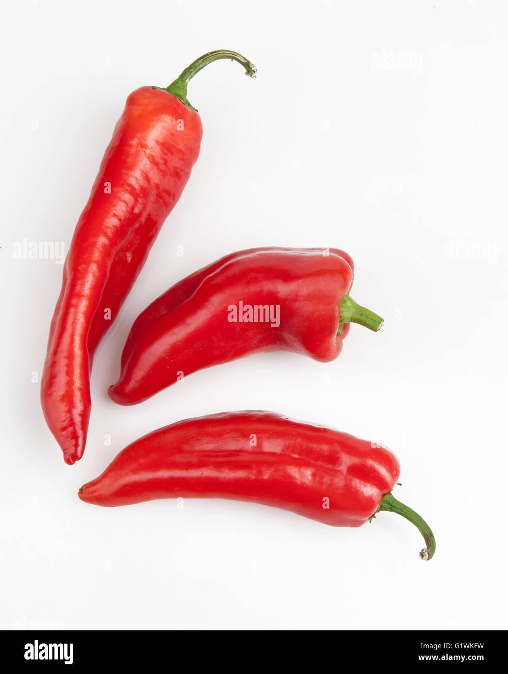 three whole red pepper isolated white Stock Photo - Alamy
