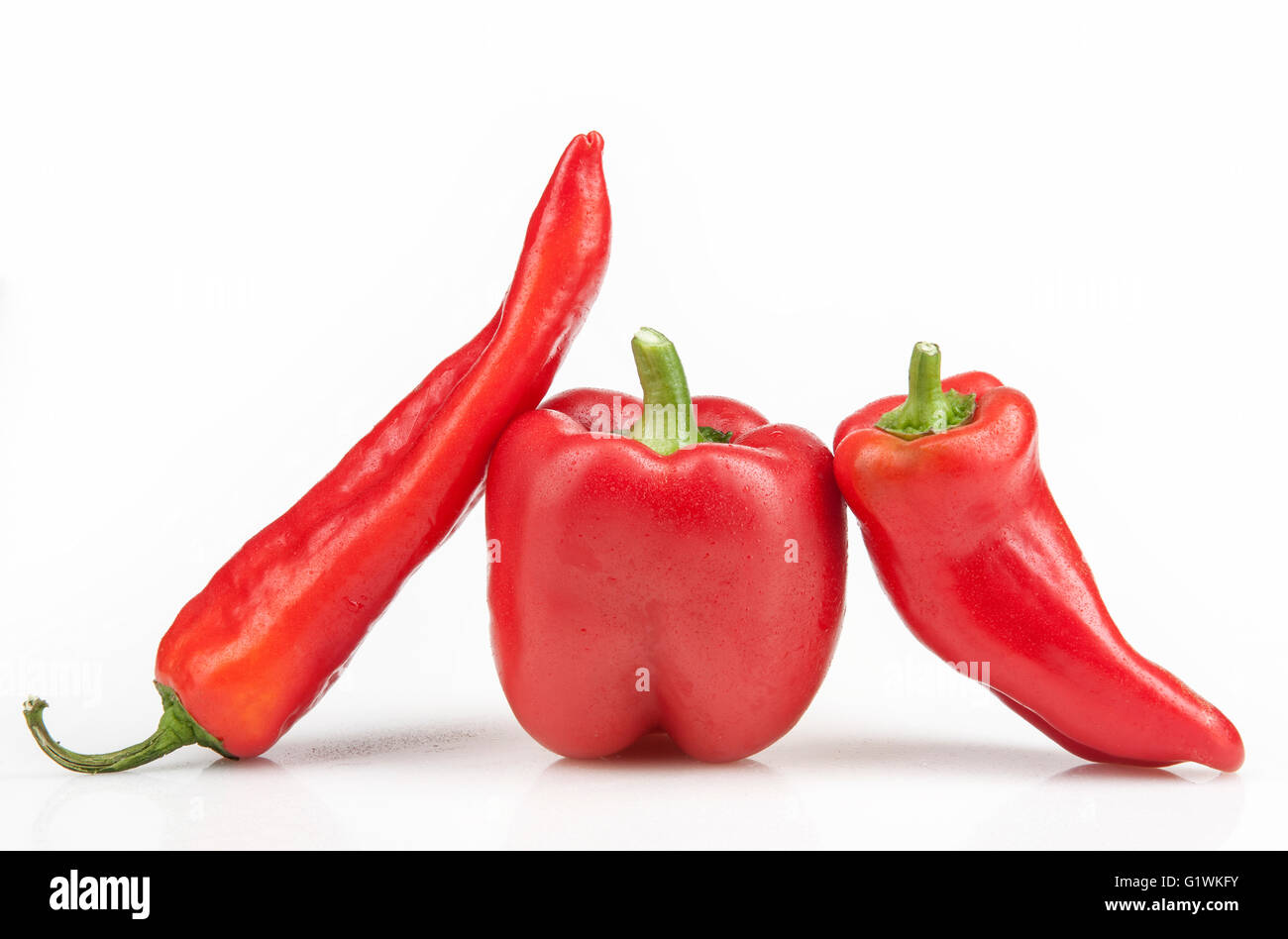 three whole red pepper isolated white Stock Photo - Alamy